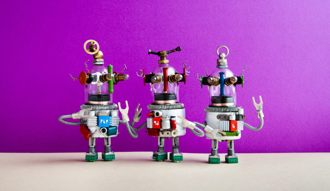 Funny glass headed ufo robots against purple wall background. Three ...